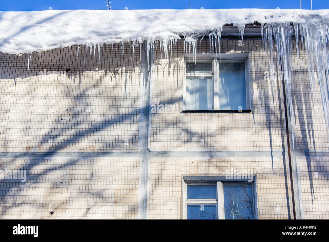 icicles hang from the roof of houses. frozen water. water aggregation ...
