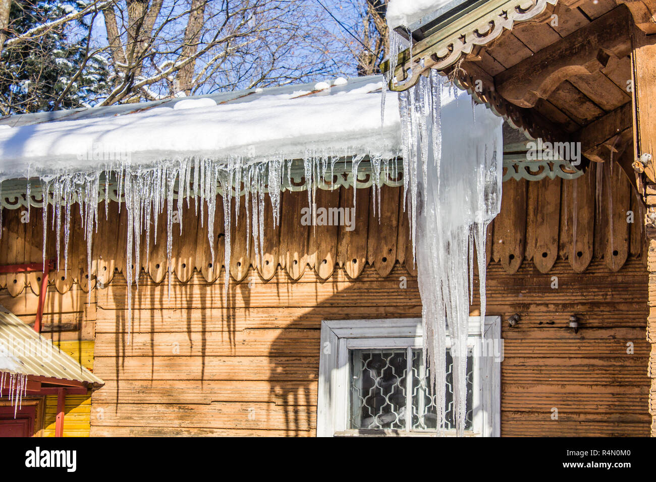 icicles hang from the roof of houses. frozen water. water aggregation ...