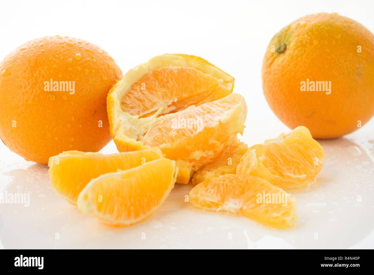 Peeled and whole oranges Stock Photo - Alamy