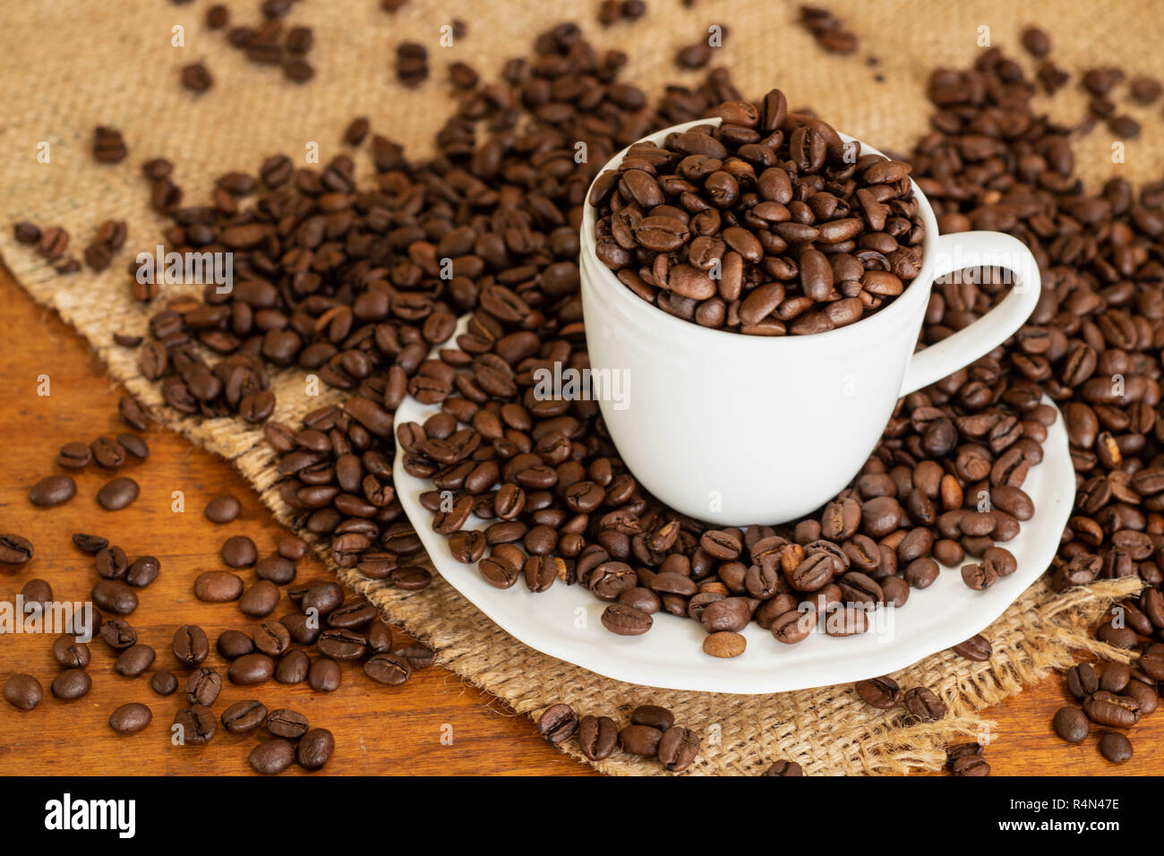 Coffee beans in cup and saucer Stock Photo - Alamy