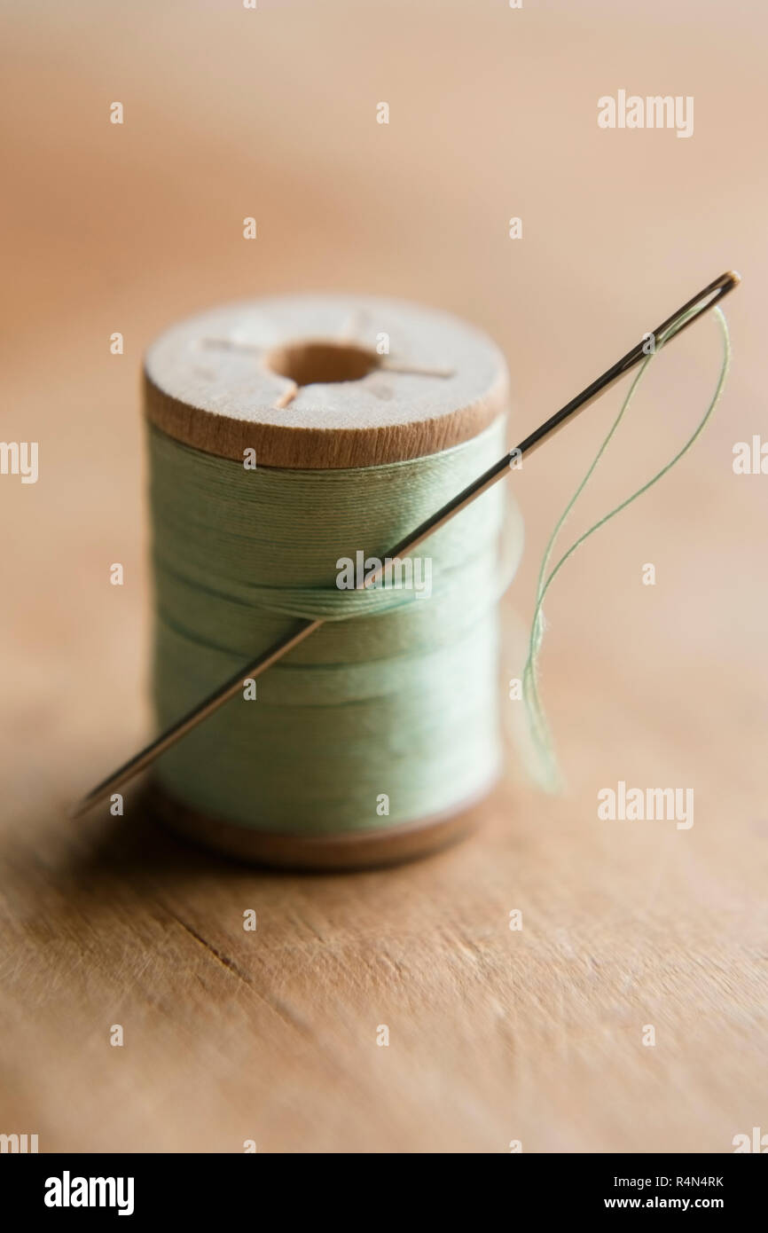 Green thread and needle Stock Photo - Alamy