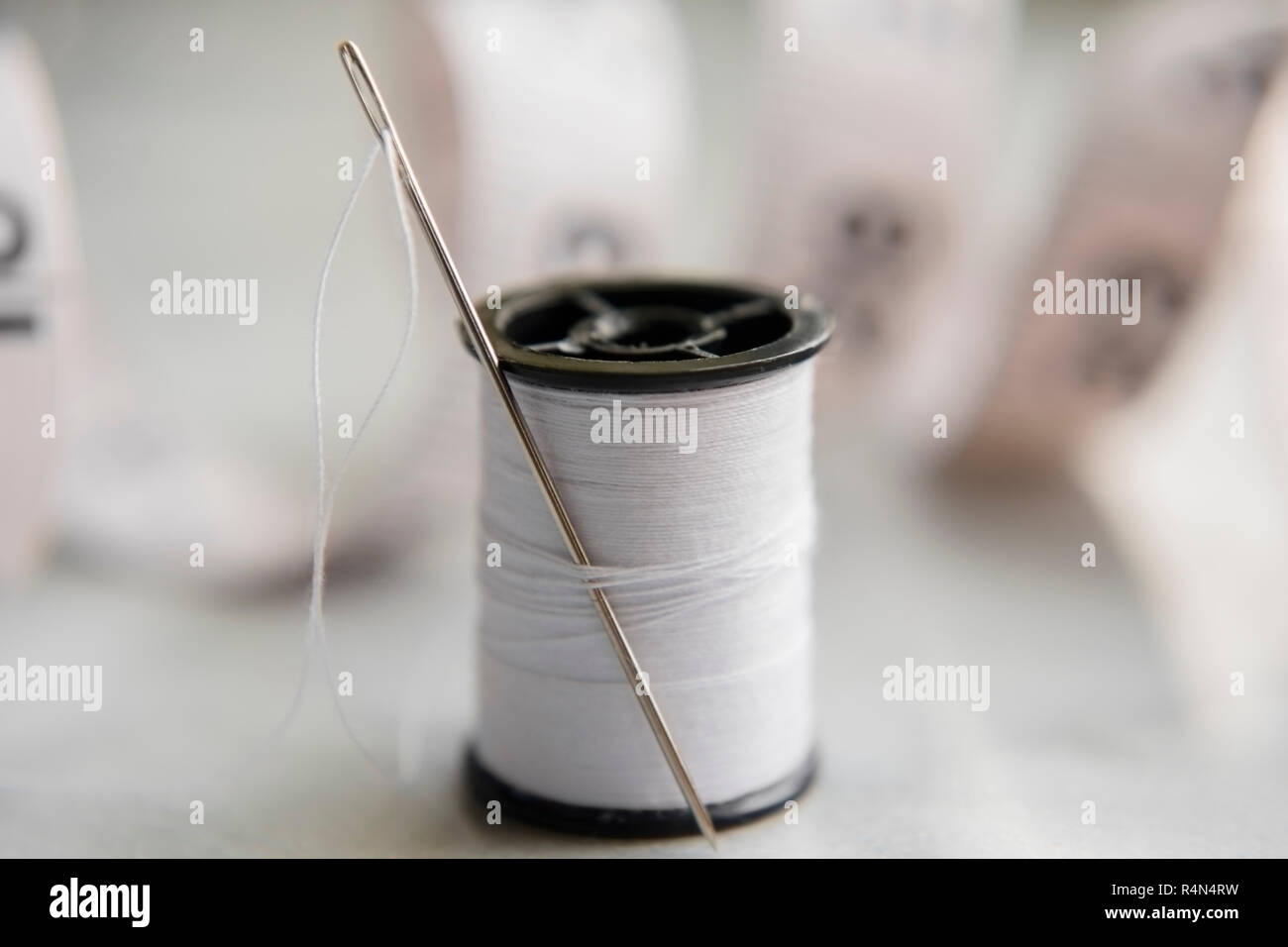White thread and needle Stock Photo - Alamy