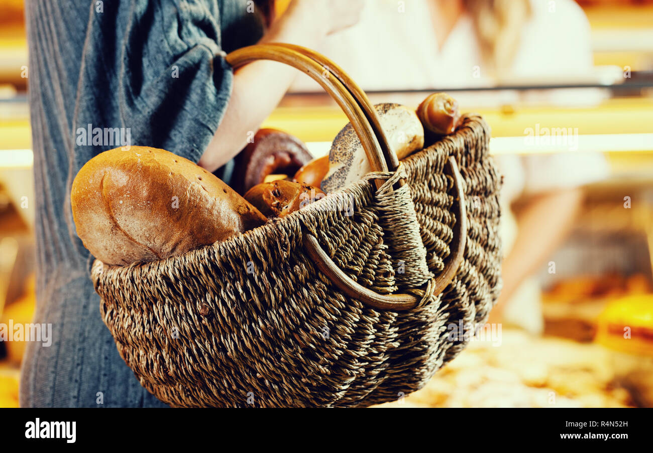 Customer shopping bread in baker carrying basket Stock Photo - Alamy