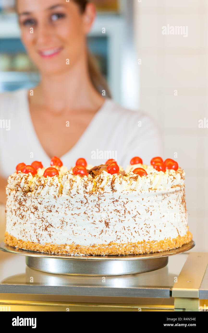 Female baker or pastry chef with torte Stock Photo - Alamy