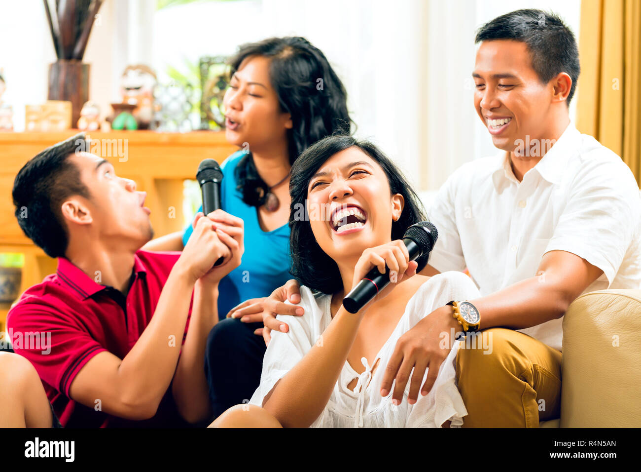 Group teenagers singing karaoke hi-res stock photography and images - Alamy