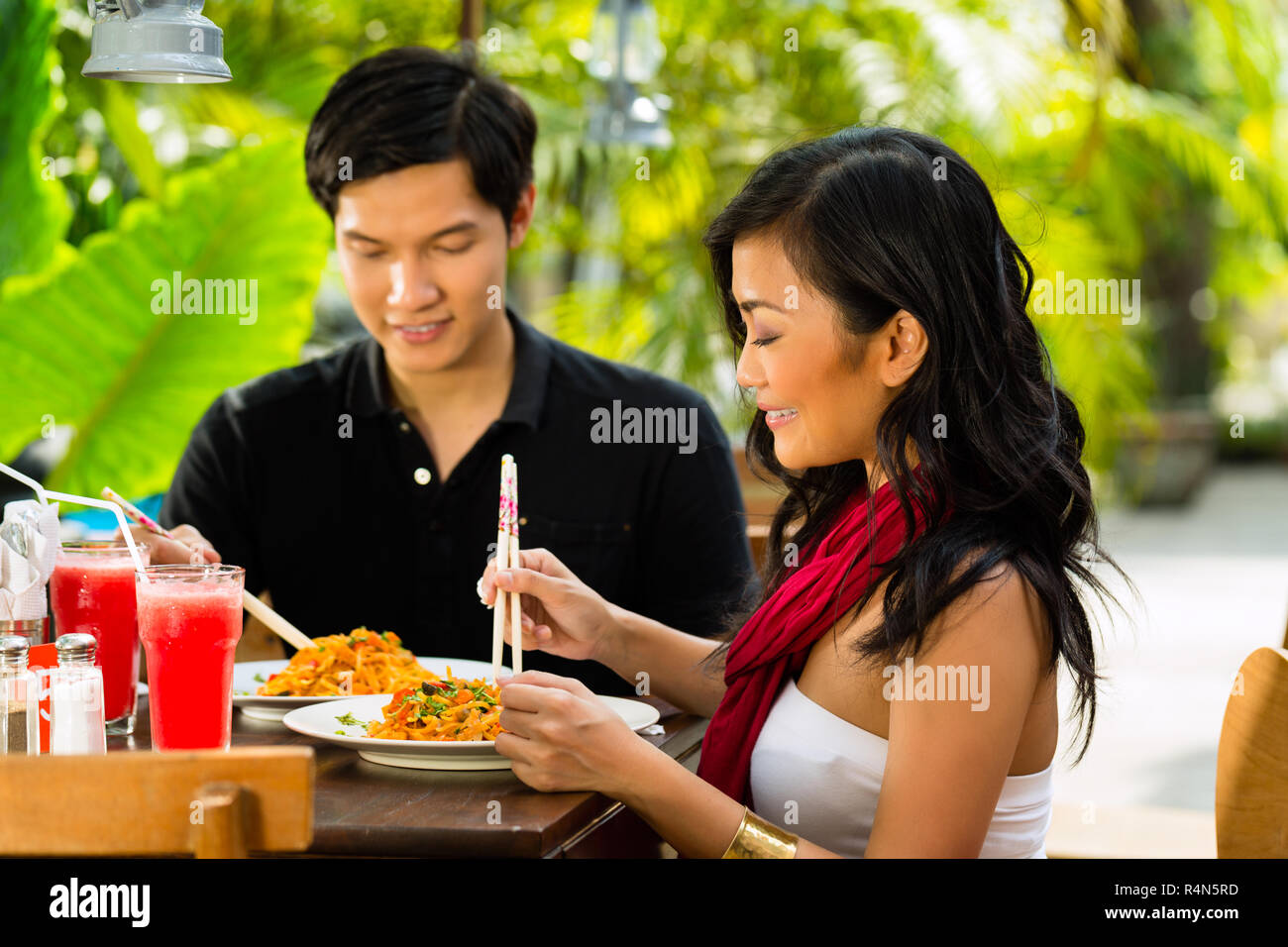 Asian man and woman in restaurant Stock Photo - Alamy