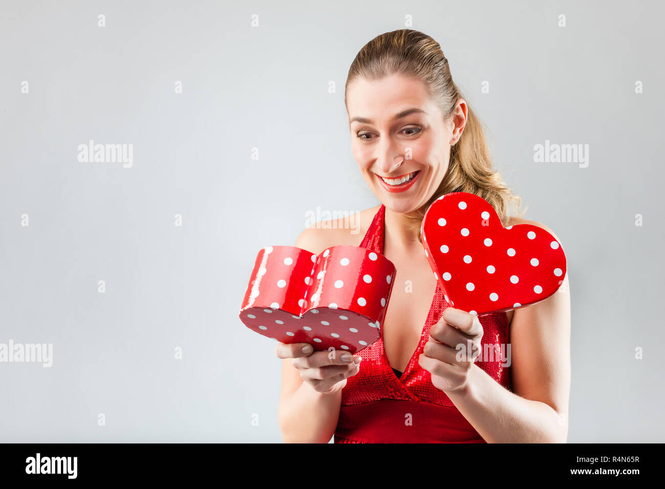 Woman opening the gift and is happy Stock Photo - Alamy