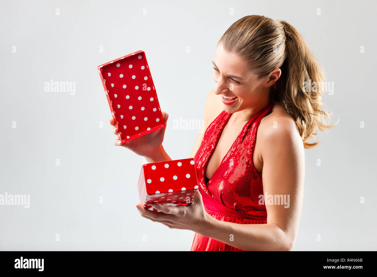 Woman opening the gift and is happy Stock Photo - Alamy