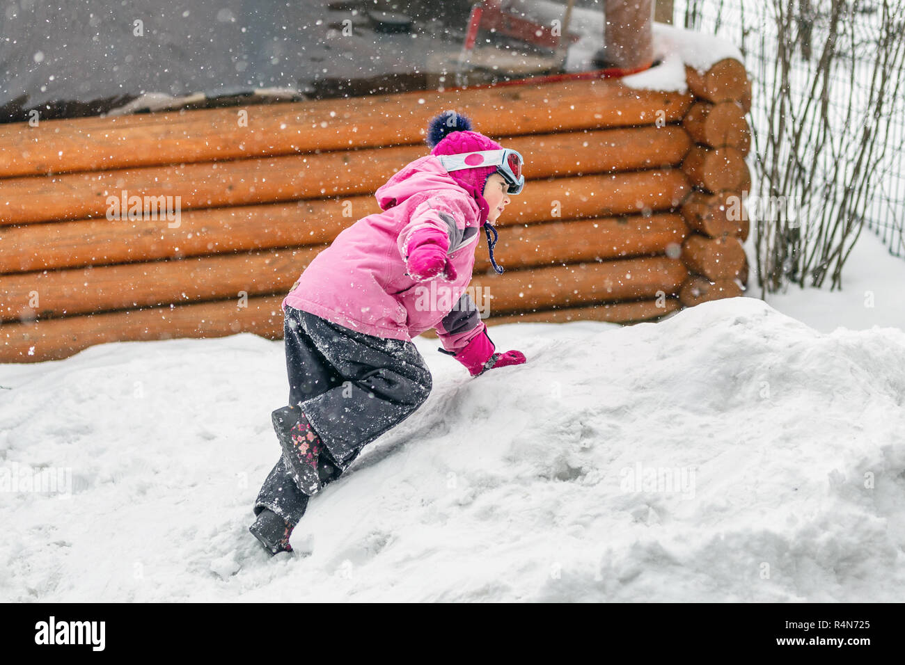 Cute little girl in pink sport suit having fun playing outdoors during ...