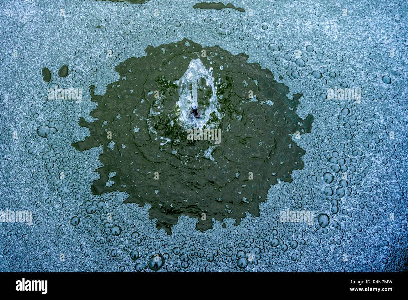 Cluster of bubbles made by a water fountain in an English garden pond ...