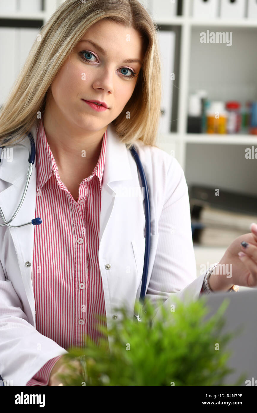 Beautiful smiling female doctor sit at workplace Stock Photo - Alamy