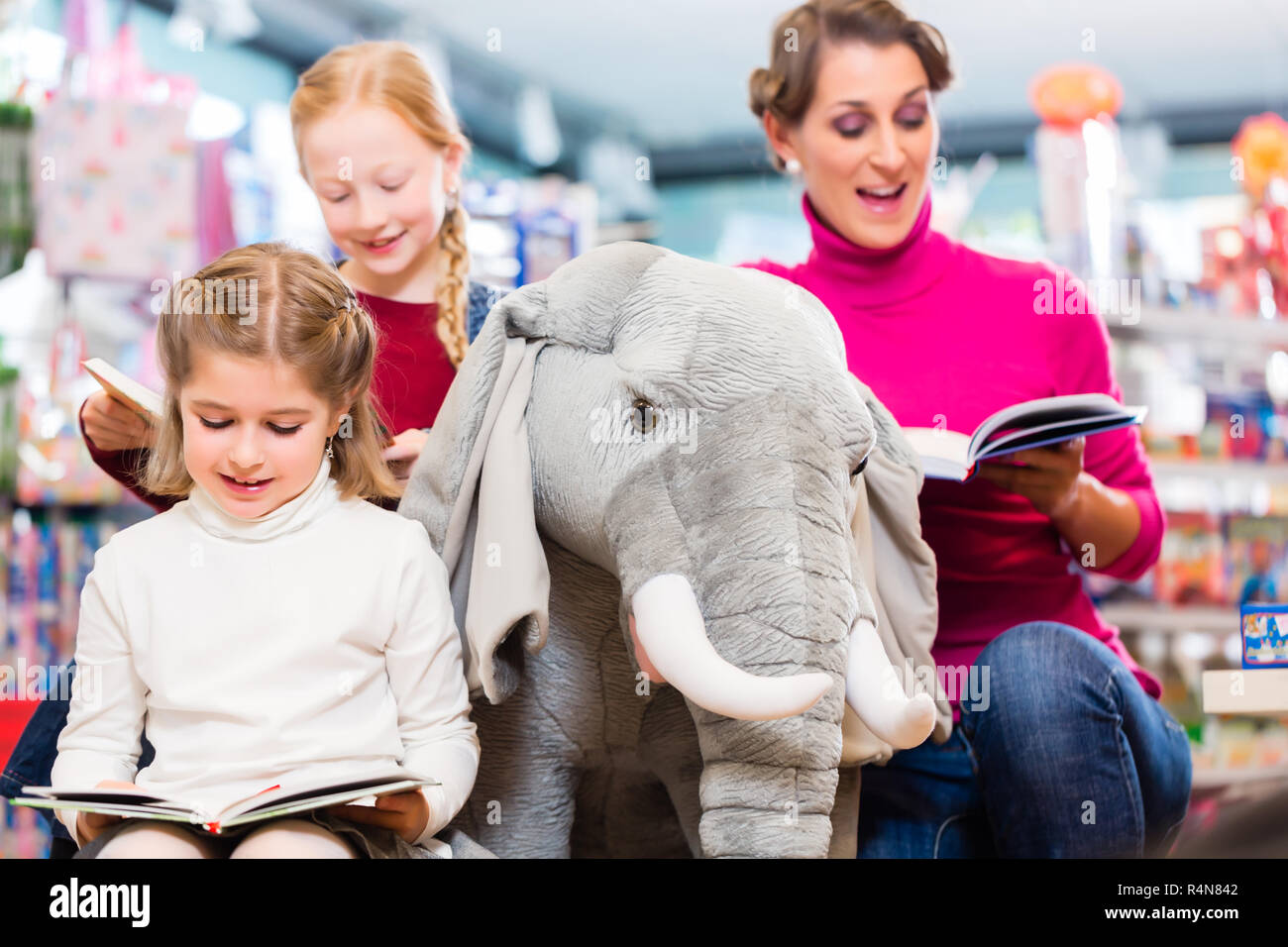 Mother with two kids shopping in toy store Stock Photo - Alamy