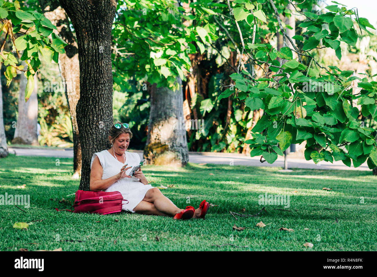 Woman under tree using hi-res stock photography and images - Alamy