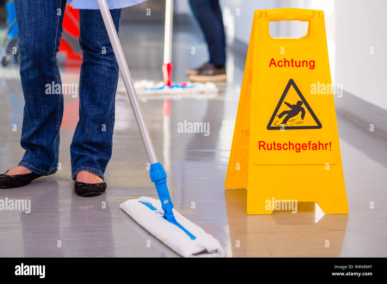 Warning sign in front of cleaning crew Stock Photo - Alamy