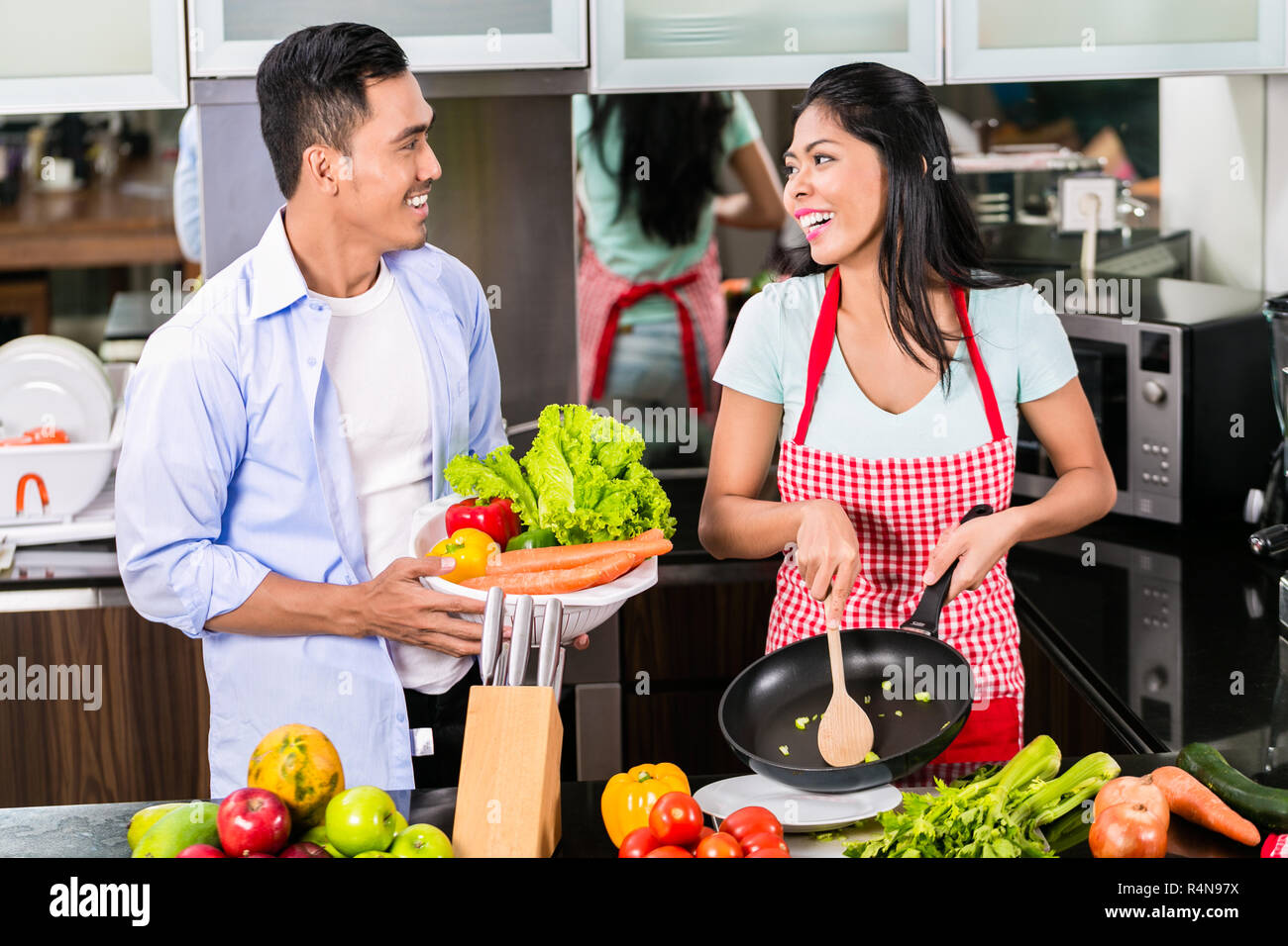 Asian man and woman cooking together Stock Photo - Alamy