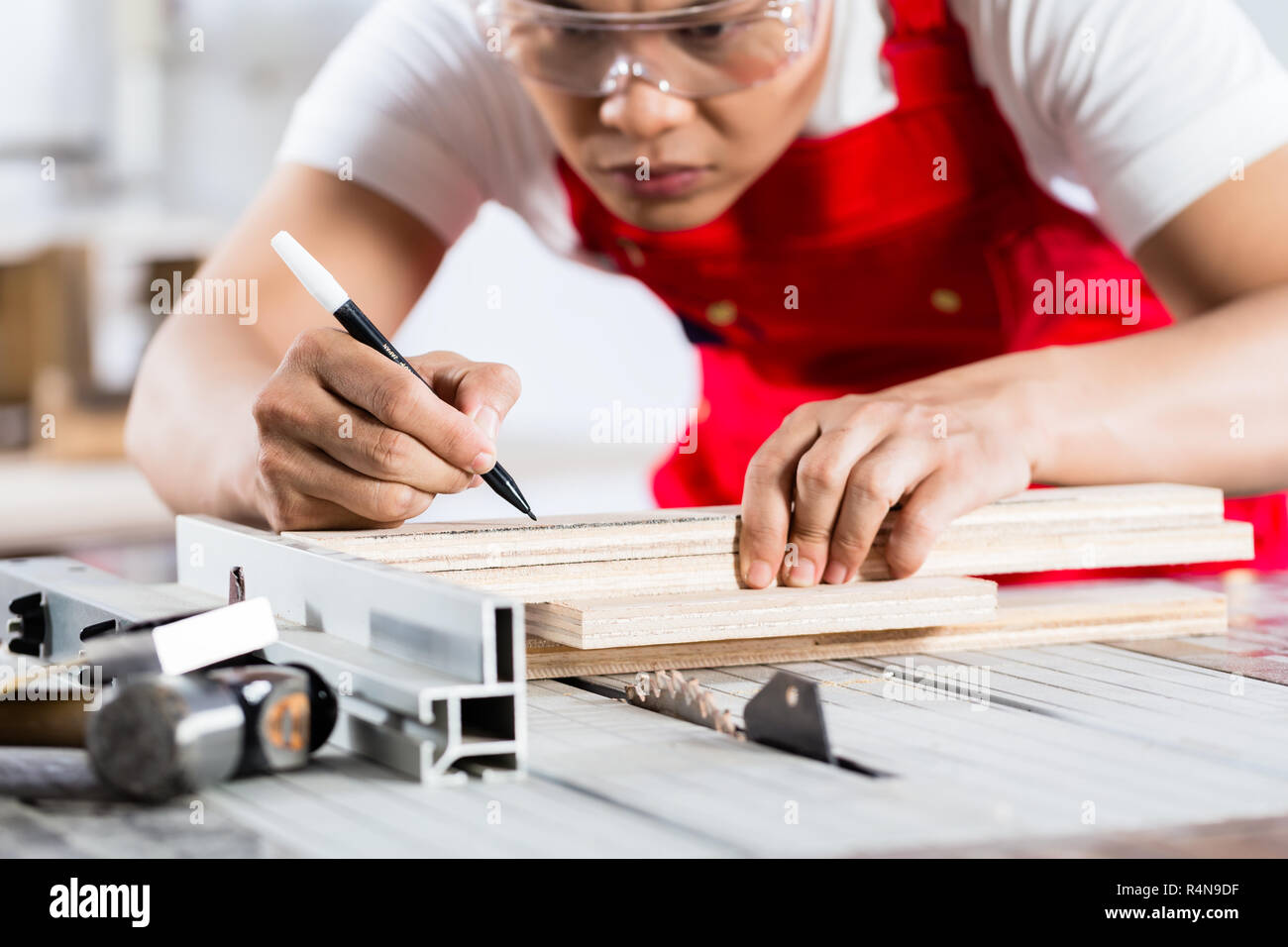 Asian Chinese Carpenter cutting wood with saw Stock Photo - Alamy