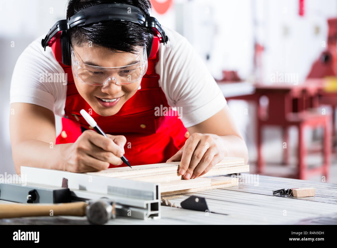 Asian Chinese Carpenter cutting wood with saw Stock Photo - Alamy