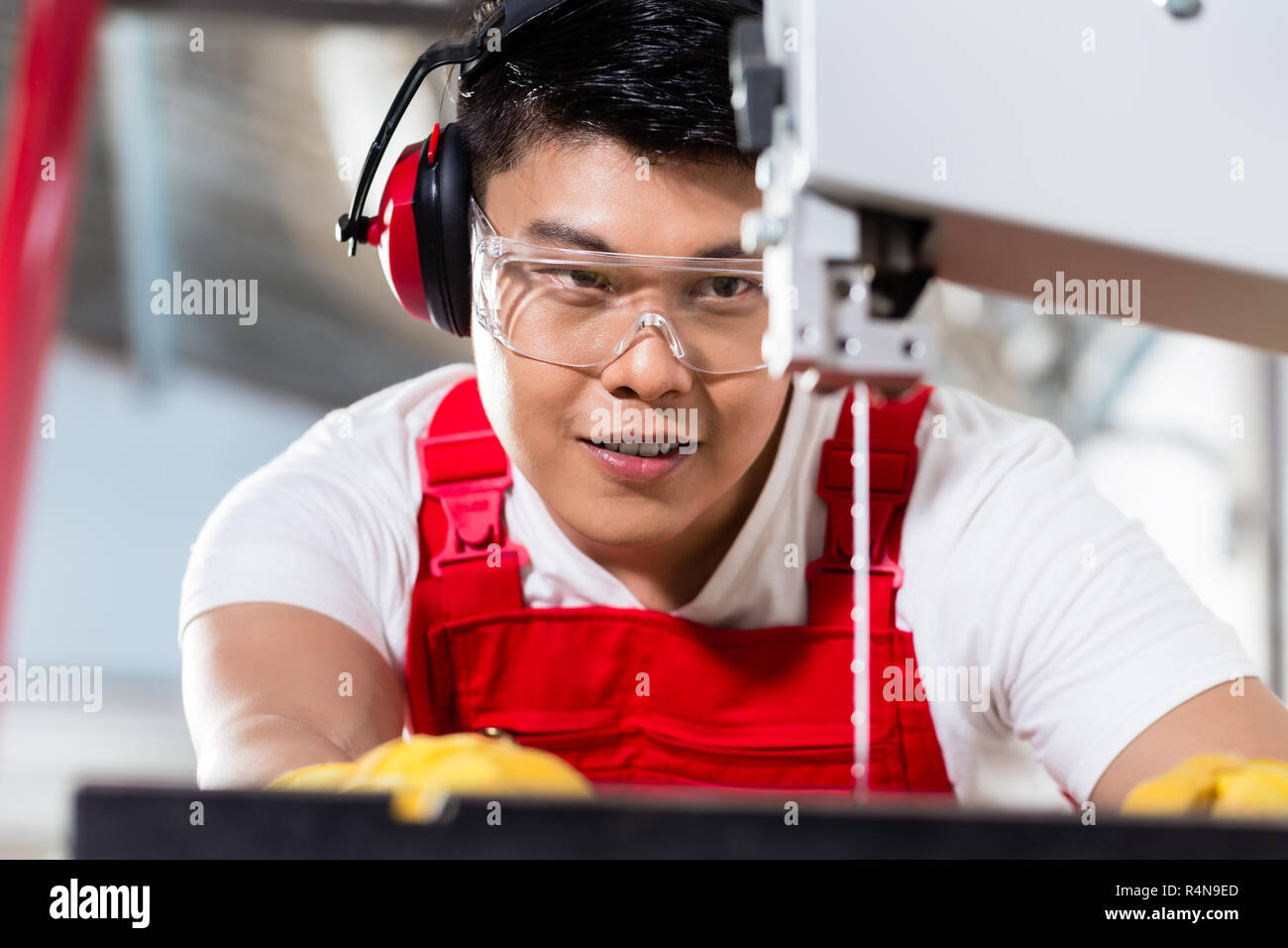 Chinese worker on saw in industrial factory Stock Photo - Alamy