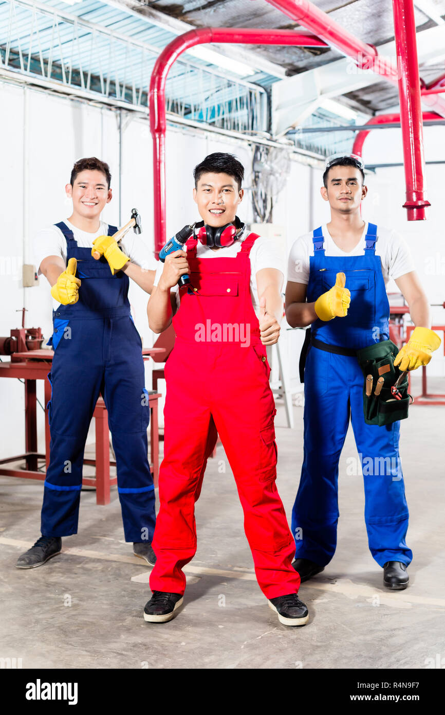 Three Asian industrial workers proud in factory Stock Photo - Alamy