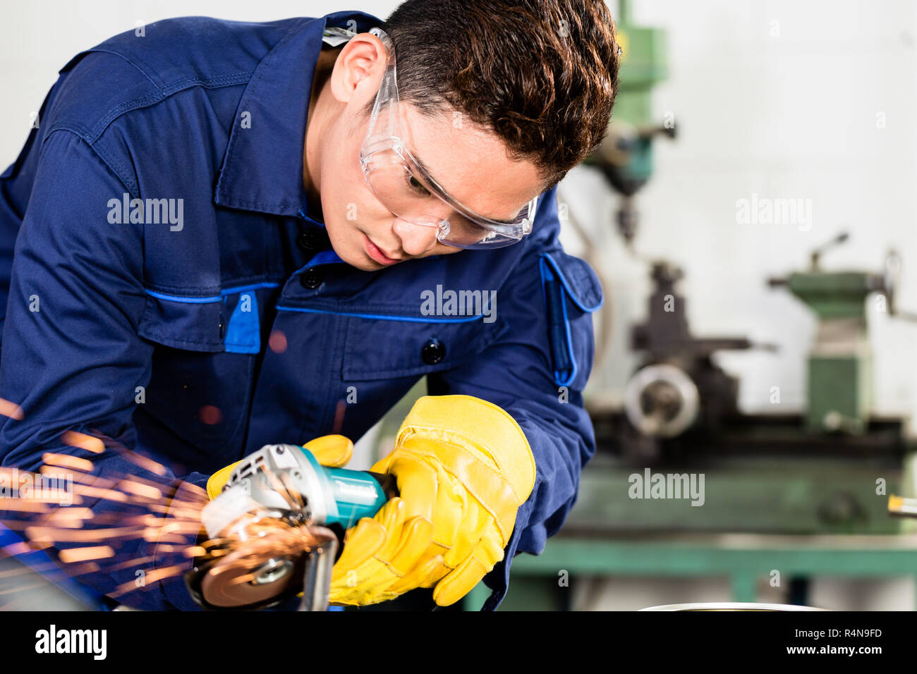 Asian worker grinding metal in manufacturing plant Stock Photo - Alamy