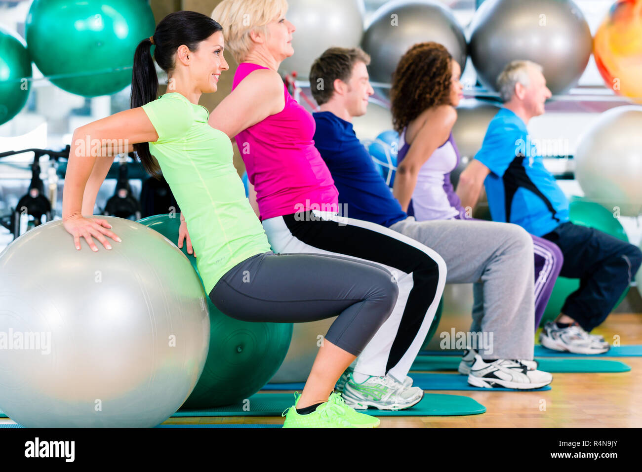Group of young and senior people exercising in gym Stock Photo - Alamy