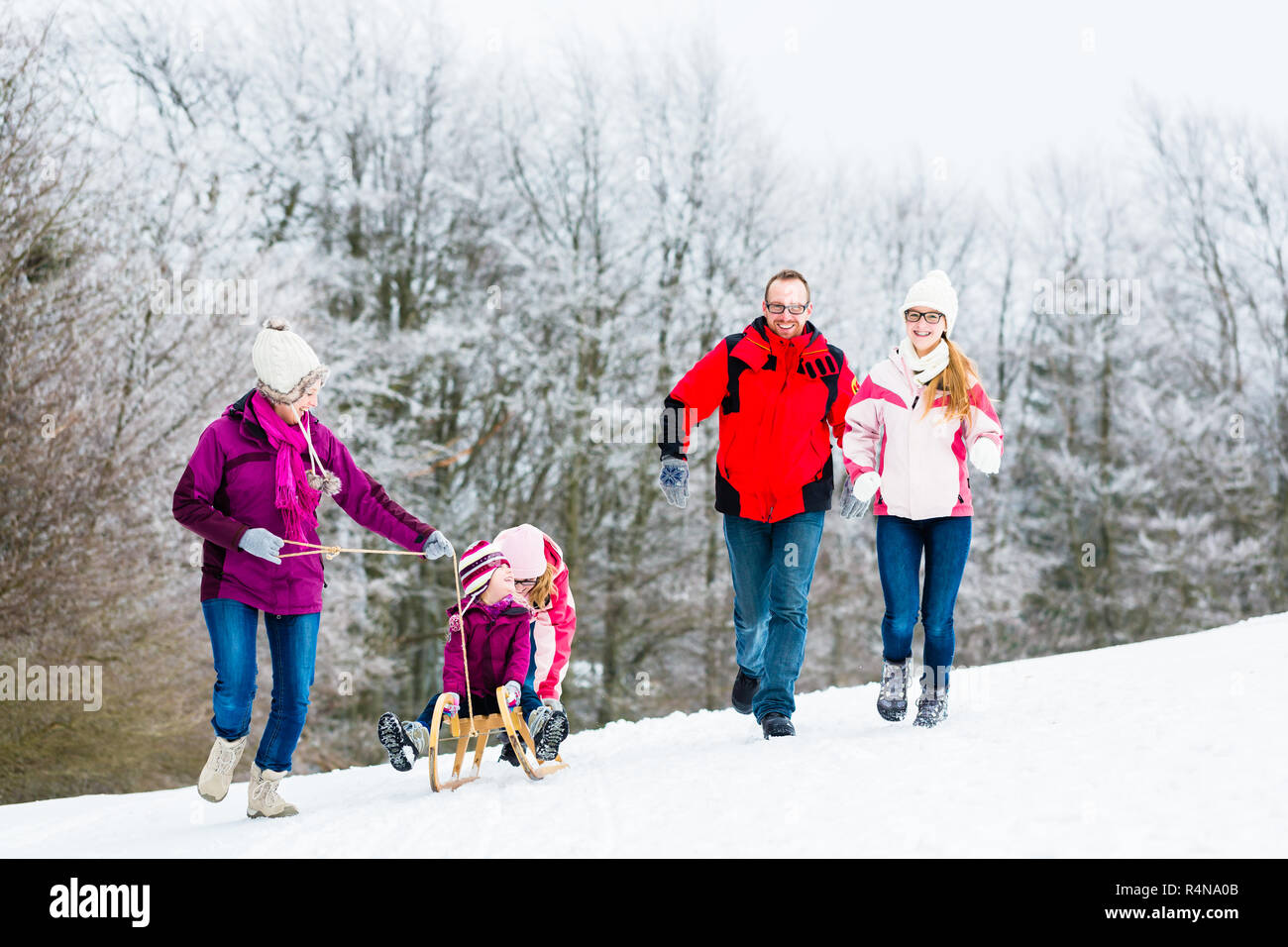Family with kids having winter walk in snow Stock Photo - Alamy