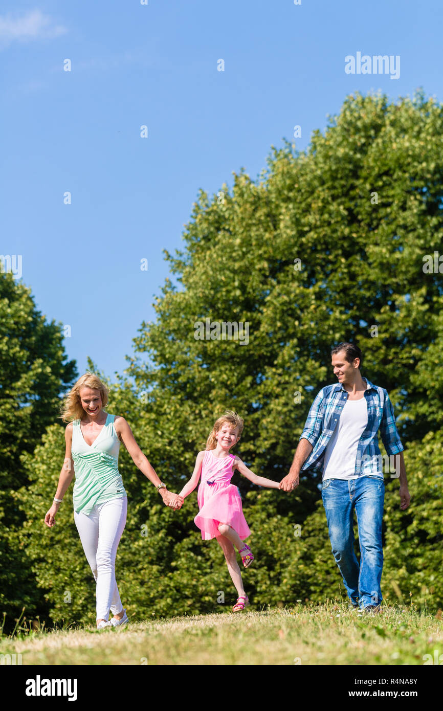 Mum, Dad and daughter running on a country lane Stock Photo - Alamy