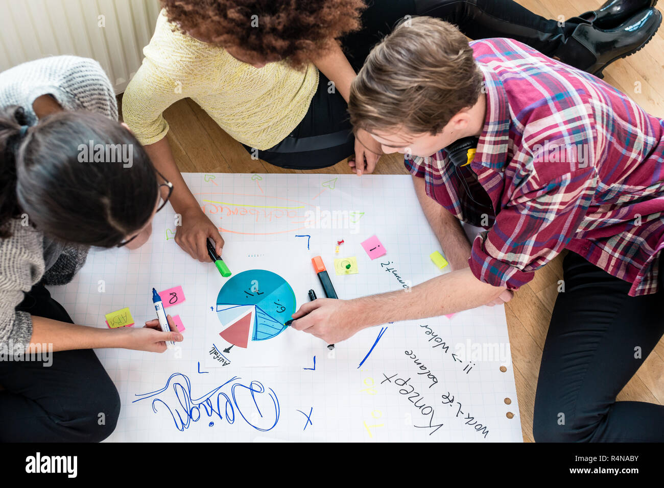 Three people writing observations during brainstorming session Stock ...