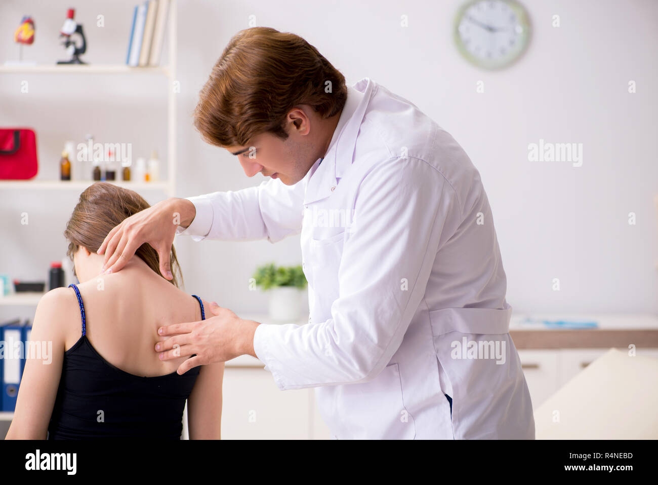 Female patient visiting young handsome doctor chiropractor Stock Photo ...