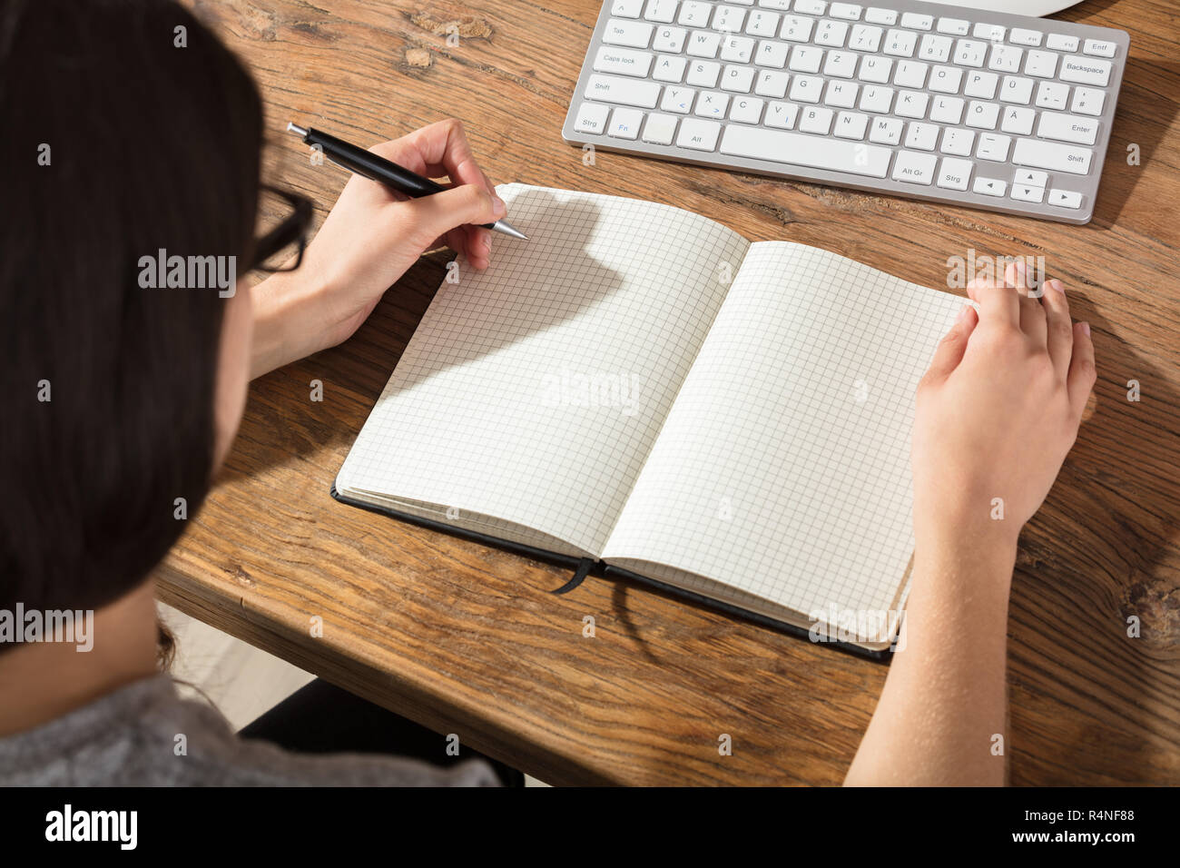 Woman Writing On Checker Note Book Stock Photo - Alamy