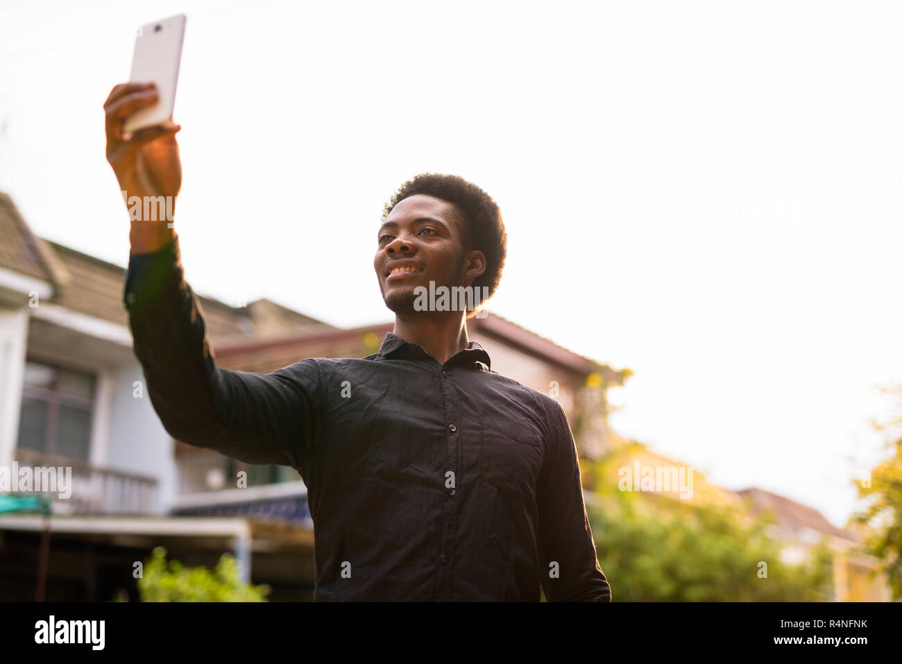 Low angle view of handsome young businessman using cell phone outside ...