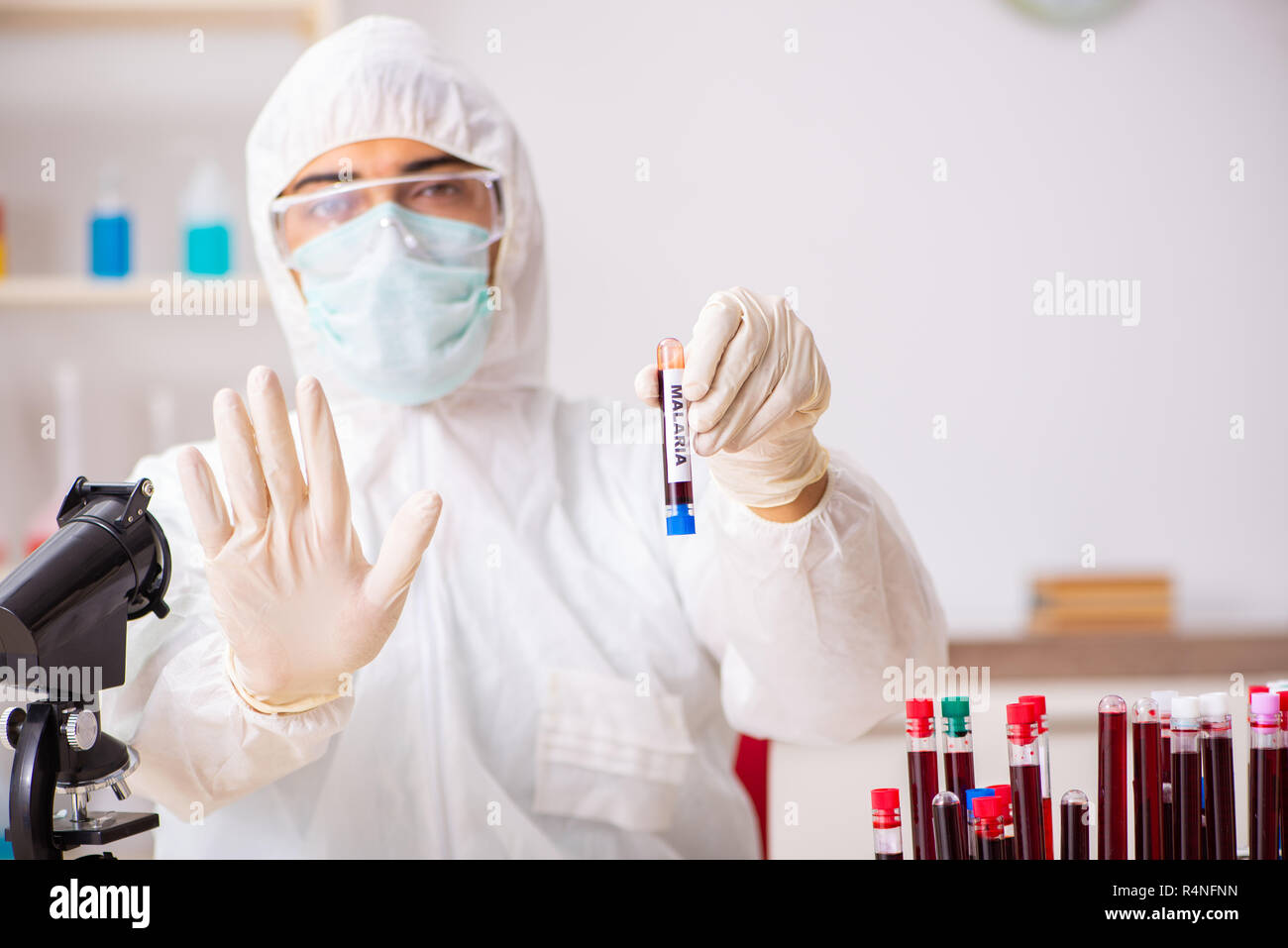 Young handsome lab assistant testing blood samples in hospital Stock ...