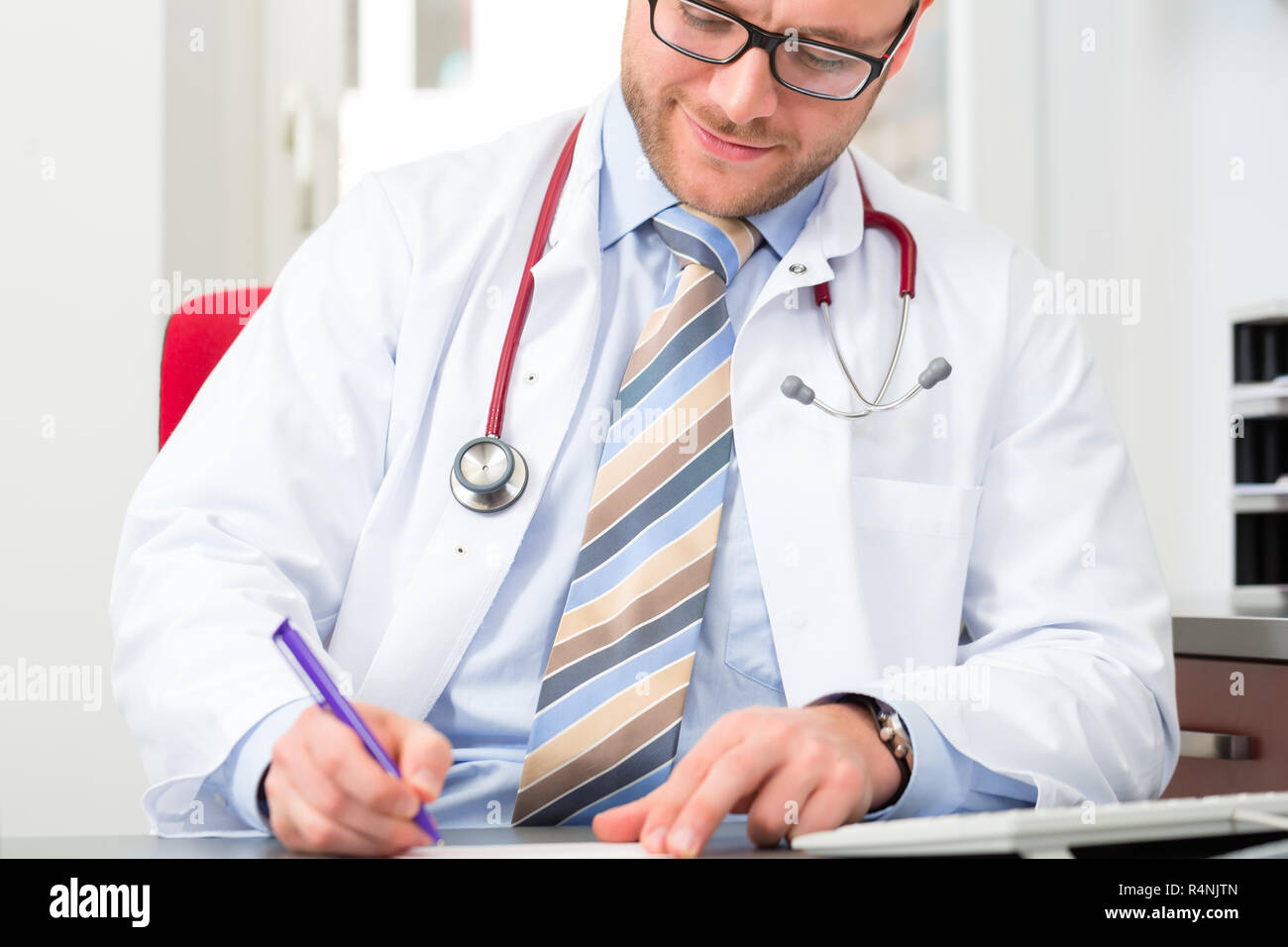 Male doctor writes prescription young hi-res stock photography and ...