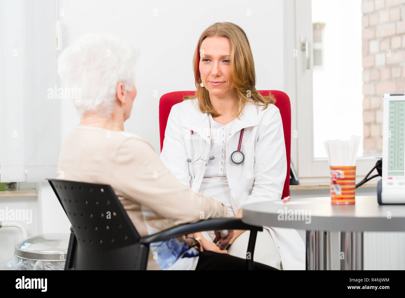 Doctor seeing senior patient in practice Stock Photo - Alamy