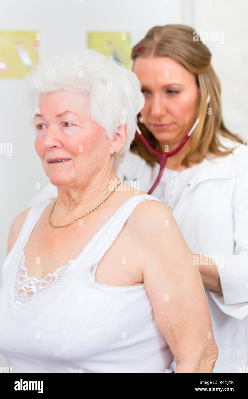 Doctor auscultating senior patient in practice Stock Photo - Alamy