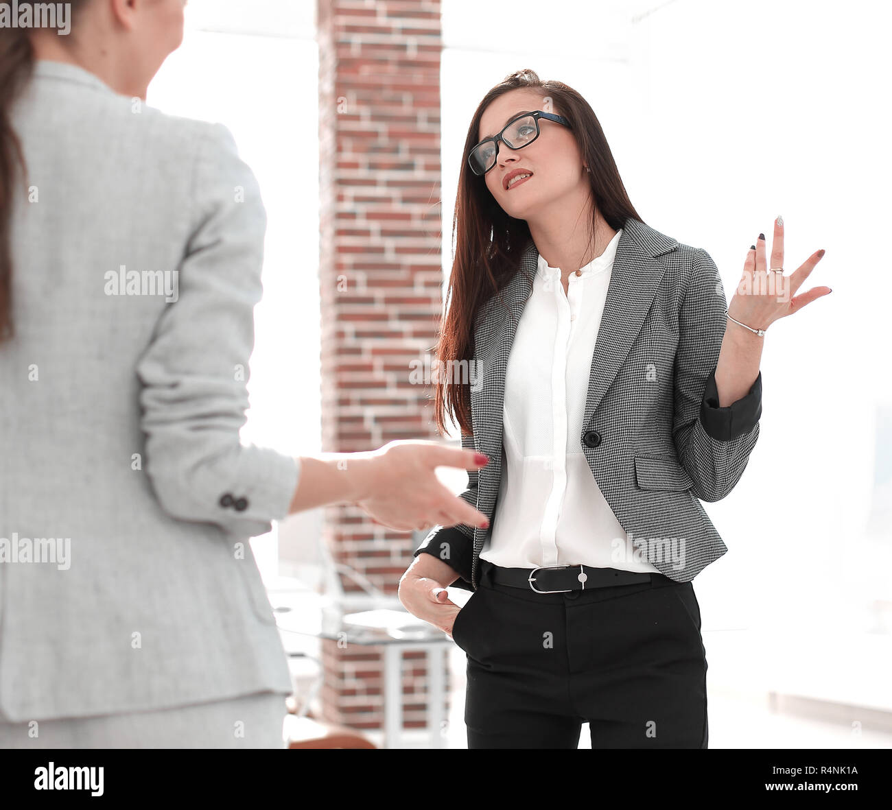 Manager talking with a client standing in the office Stock Photo - Alamy