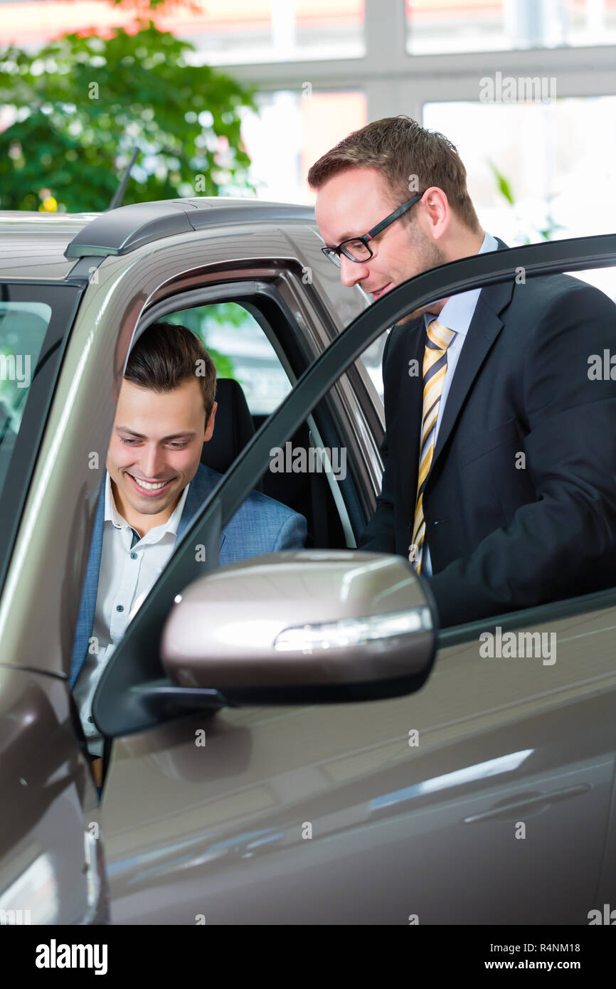 Customer buying new car in auto dealership Stock Photo - Alamy
