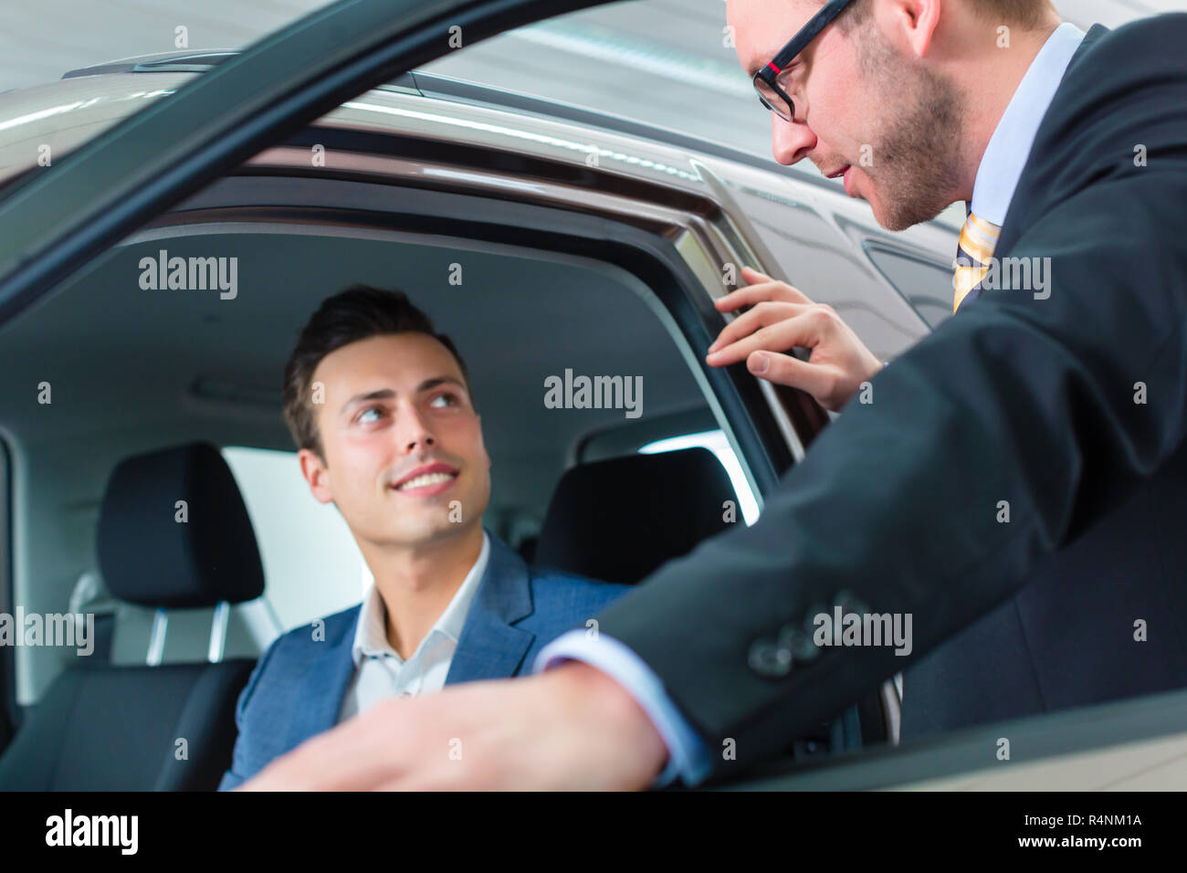 Customer buying new car in auto dealership Stock Photo - Alamy