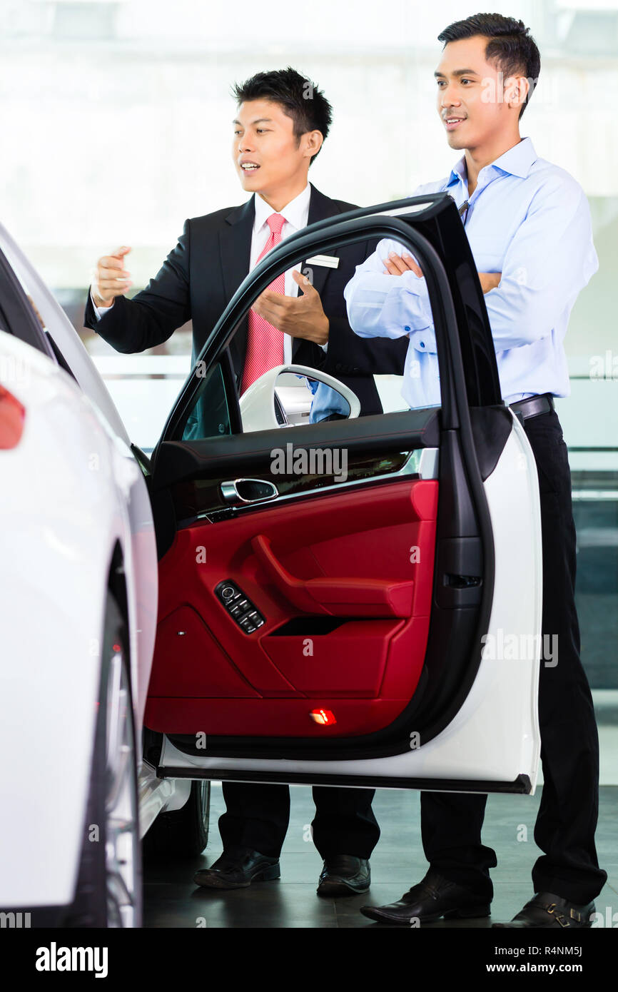 Asian Car Salesman selling auto to customer Stock Photo - Alamy