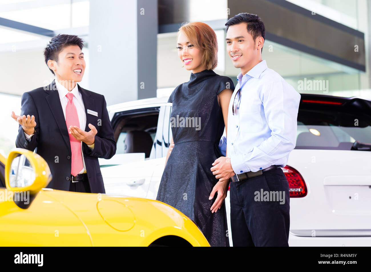 Asian couple buying car in dealership Stock Photo - Alamy