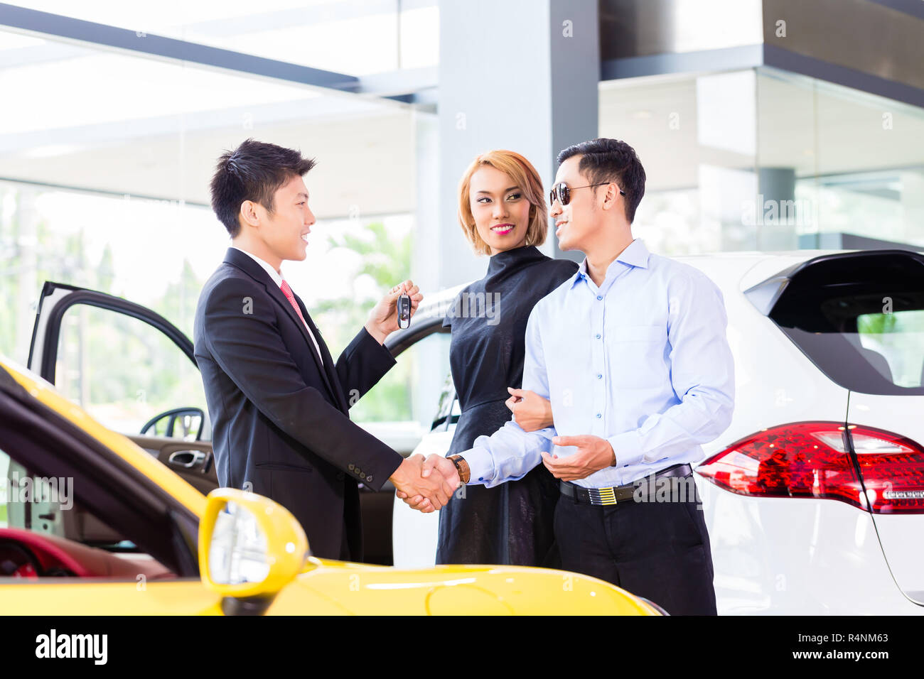 Asian couple buying car in dealership Stock Photo - Alamy
