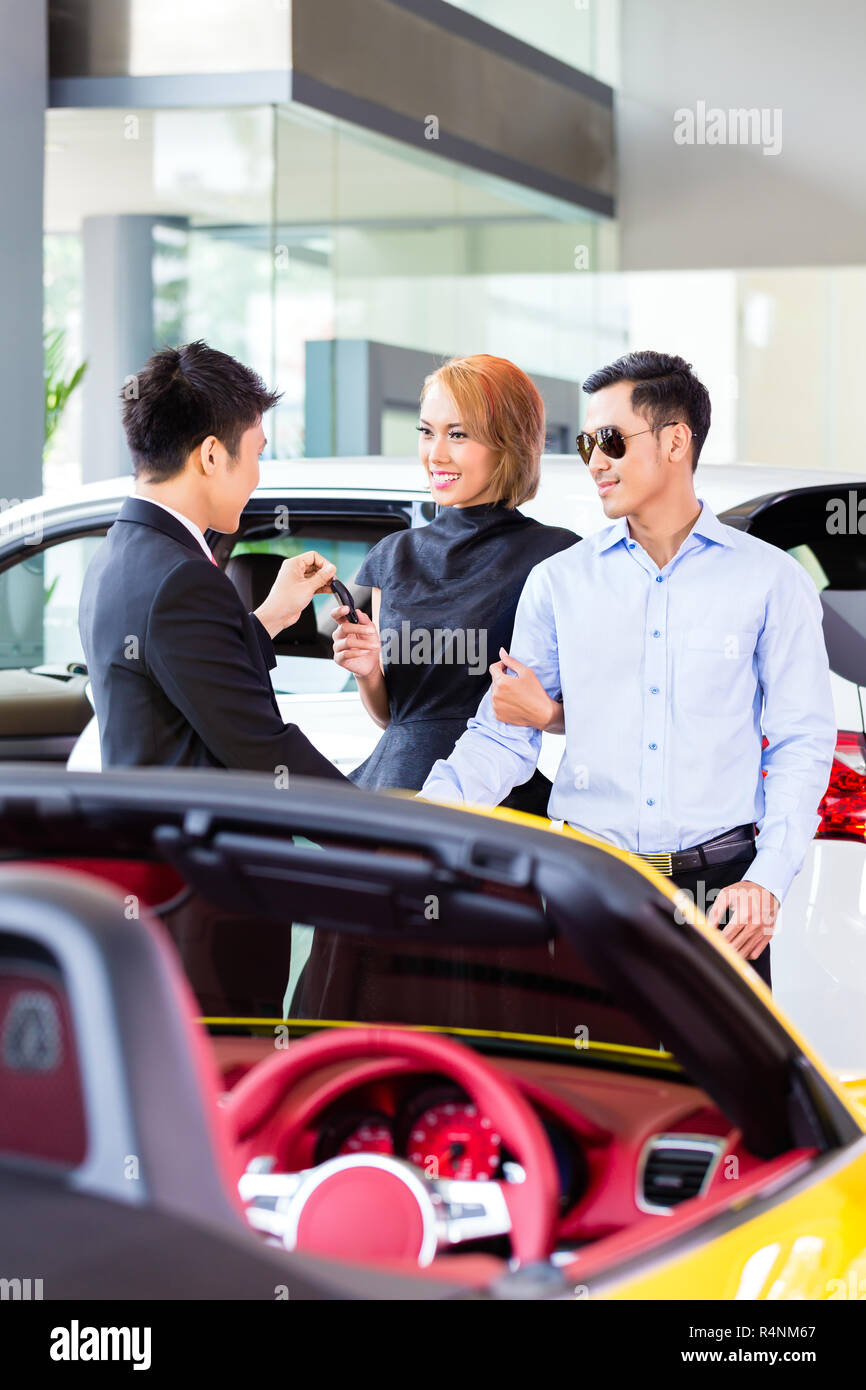 Asian couple buying car in dealership Stock Photo - Alamy