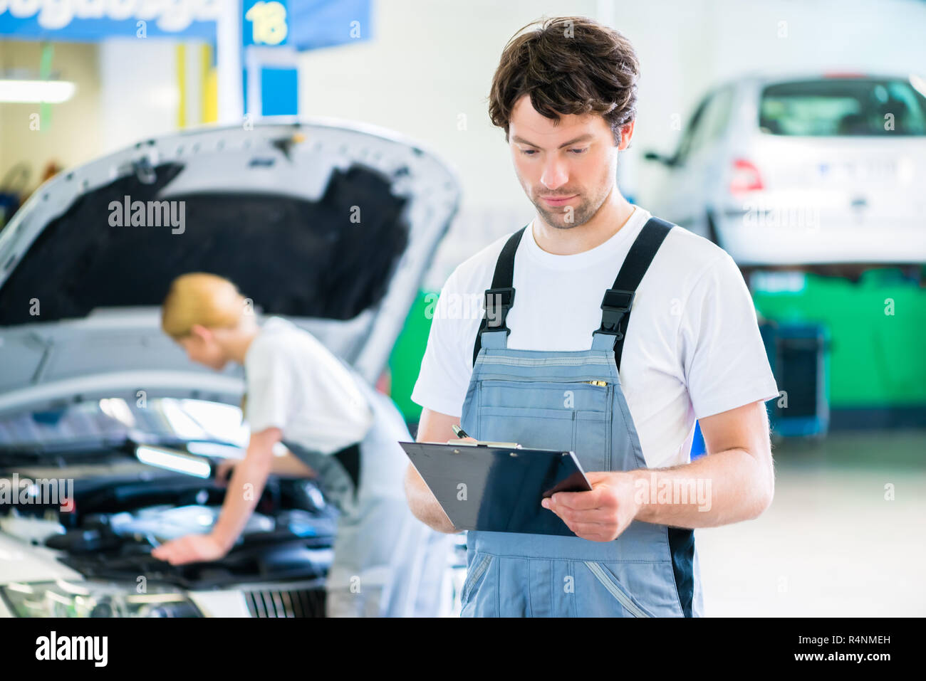 Car Mechanic team working in auto workshop Stock Photo - Alamy