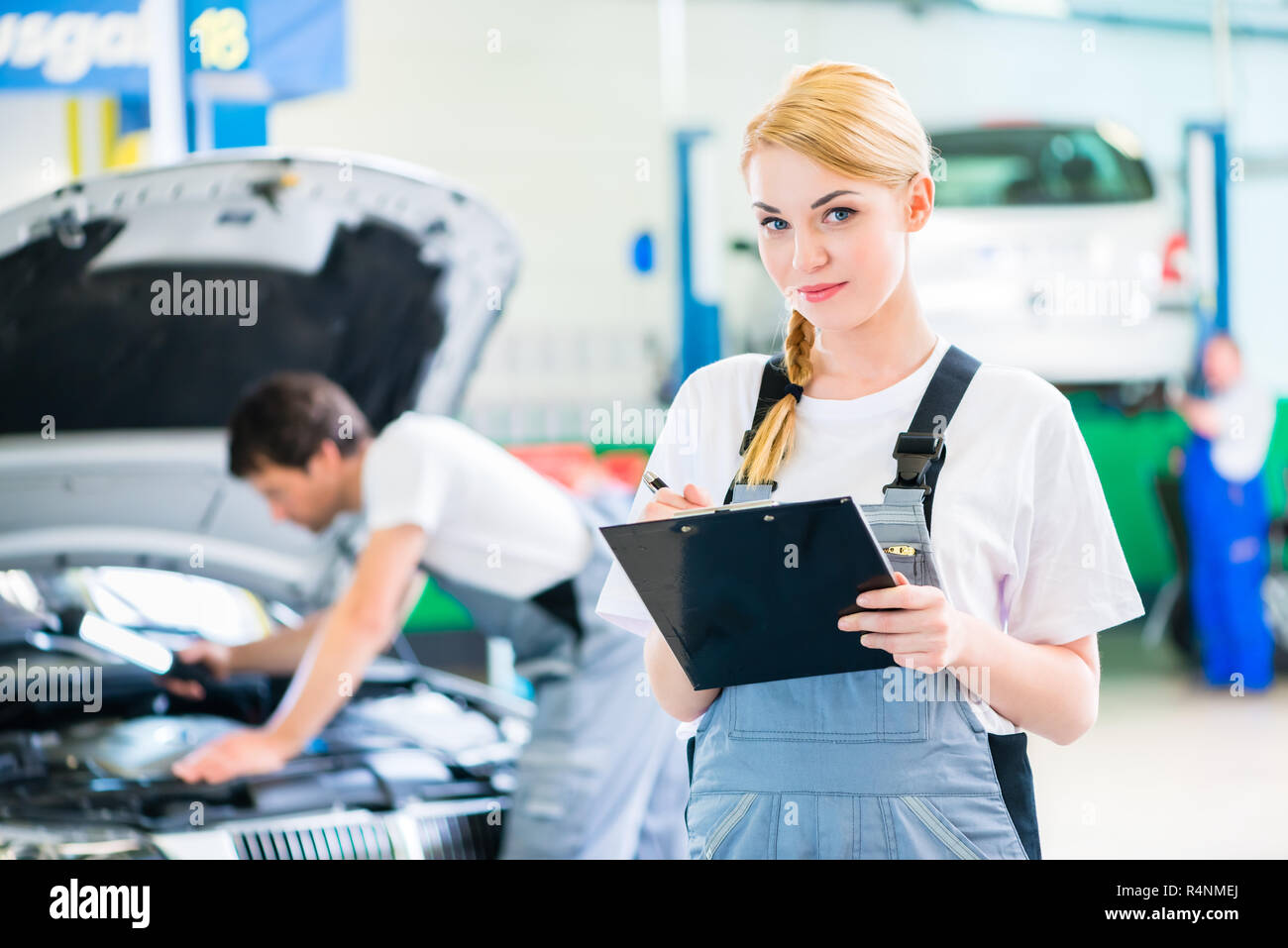 Mechanic team working in car workshop Stock Photo - Alamy