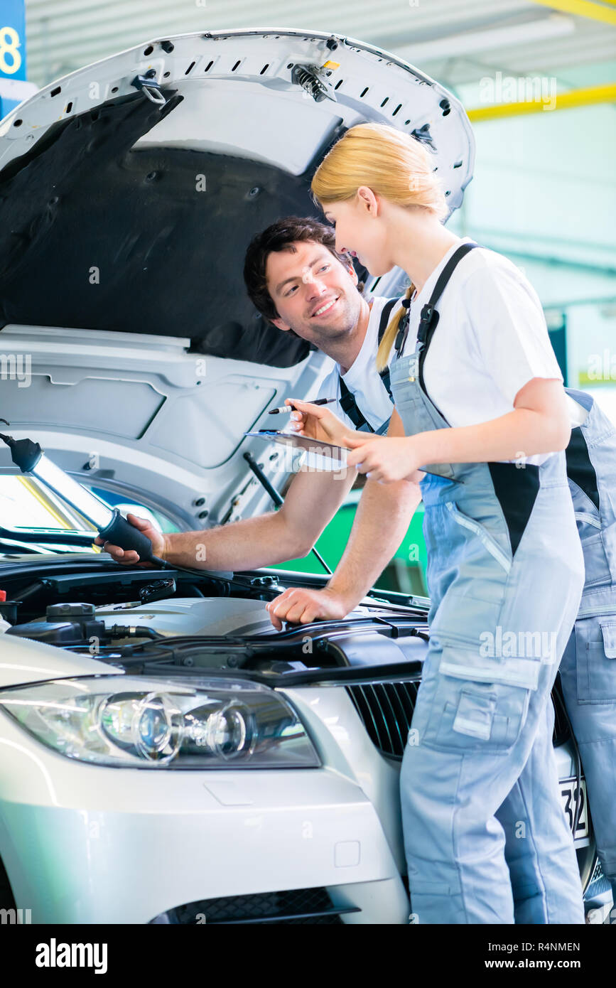 Mechanic team working in car workshop Stock Photo - Alamy