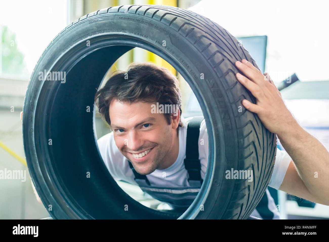 Auto mechanic changing tire in car workshop Stock Photo - Alamy