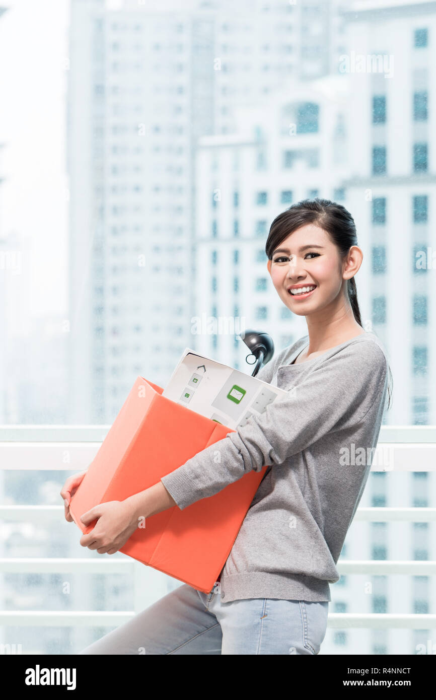 Young asian girl carrying removal crate Stock Photo - Alamy