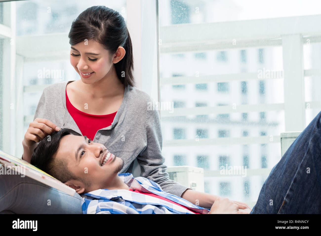 Asian girl caressing her boyfriend Stock Photo - Alamy