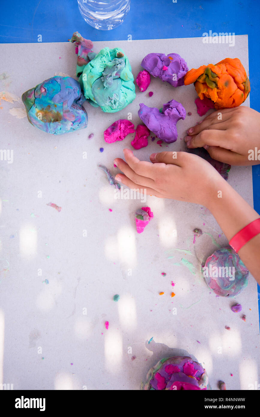 top view of kid hands Playing with Colorful Clay in outdoor Playground ...