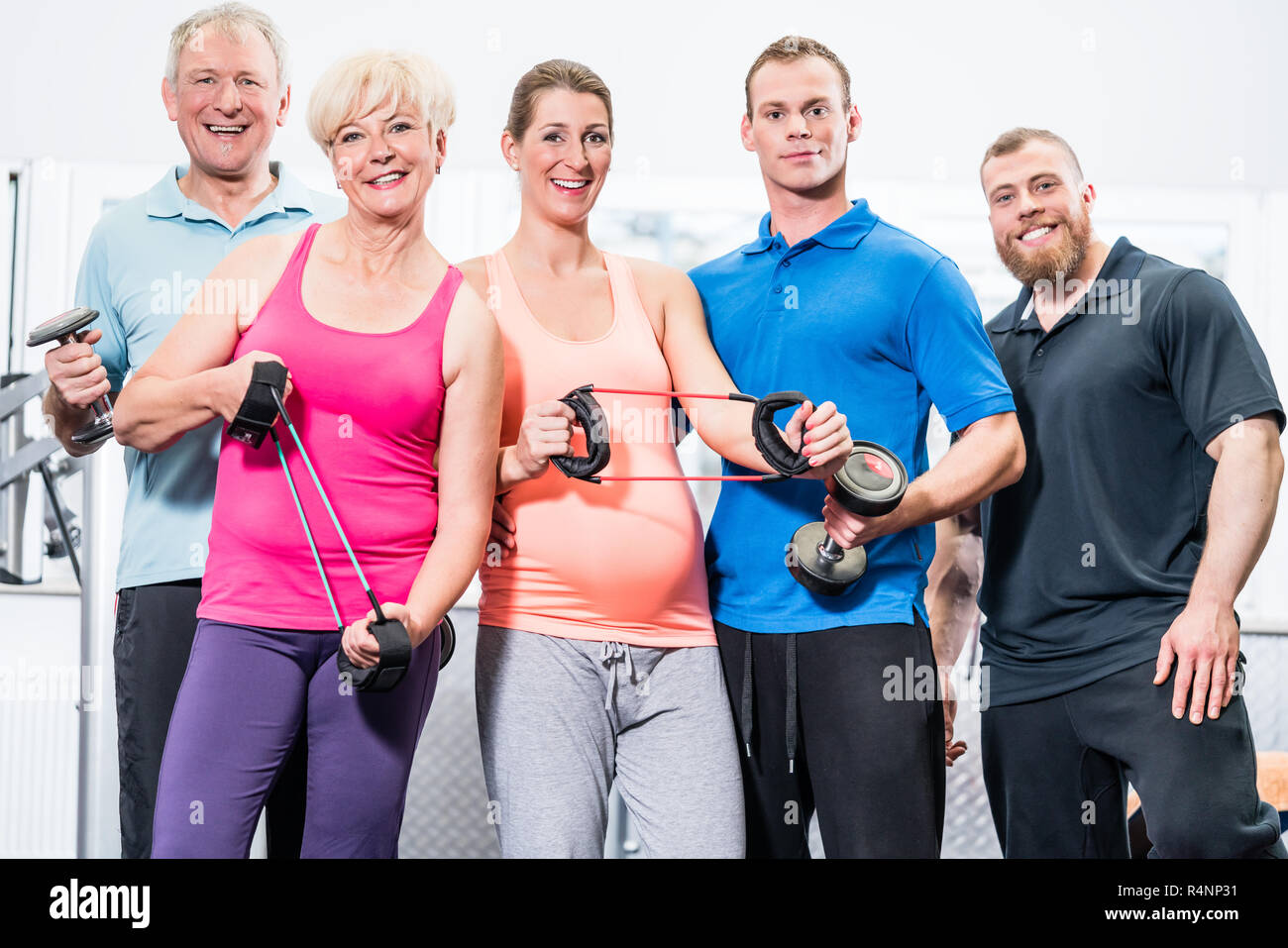 Group of people in gym with stretch bands and dumbbells Stock Photo - Alamy